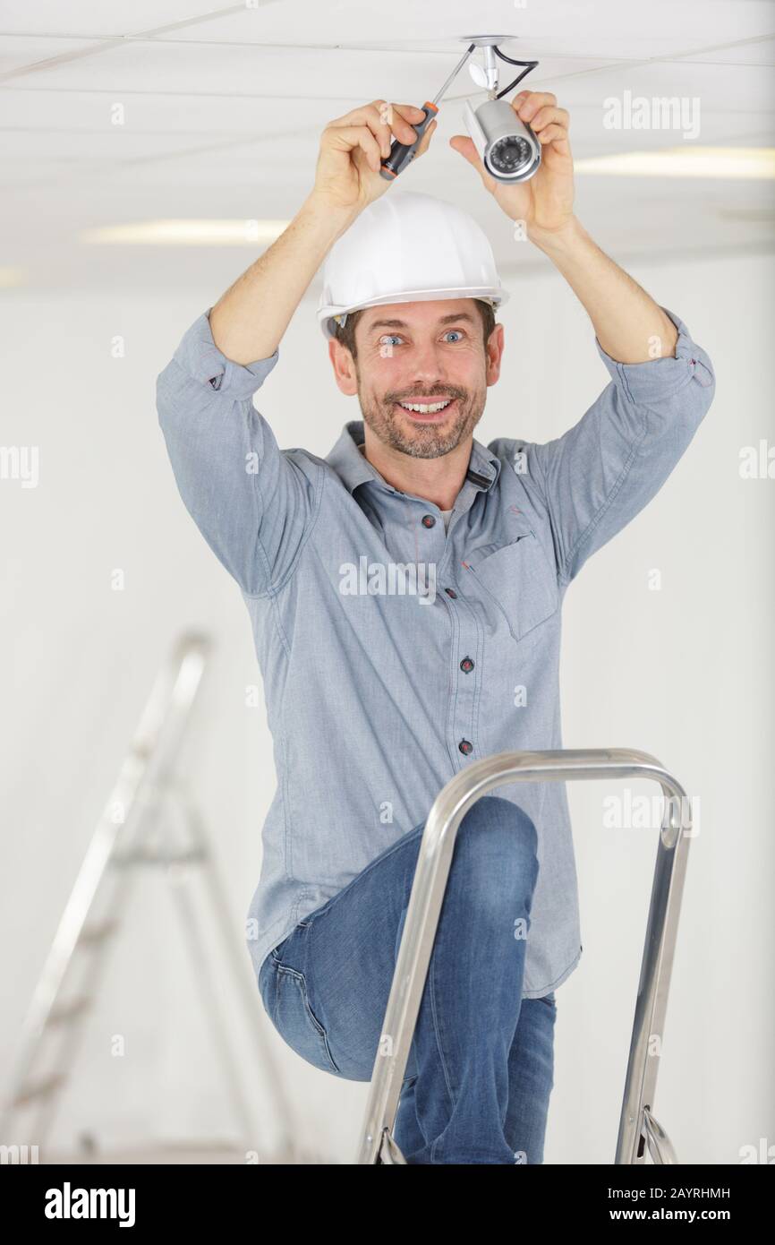 man install surveillance ip camera for home security Stock Photo - Alamy