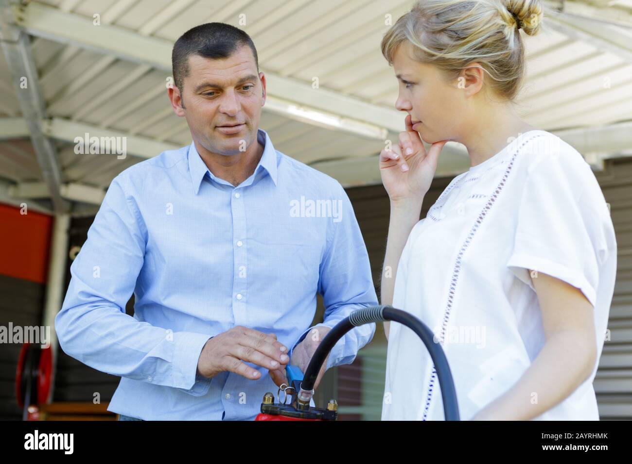 man explaining to woman the procedure to use fire extinguisher Stock ...