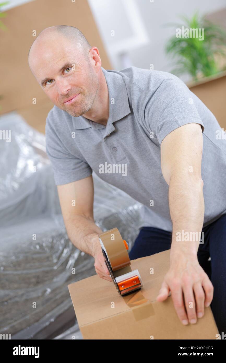 man taping a box while doing packing Stock Photo - Alamy