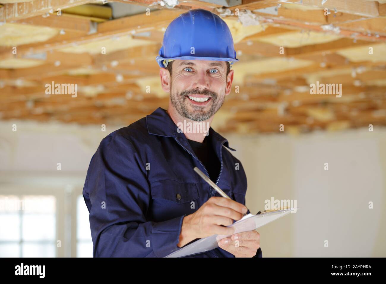 smiling worker in front of a construction site Stock Photo - Alamy