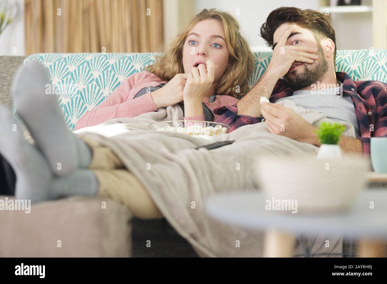 scared couple watching a horror movie Stock Photo - Alamy
