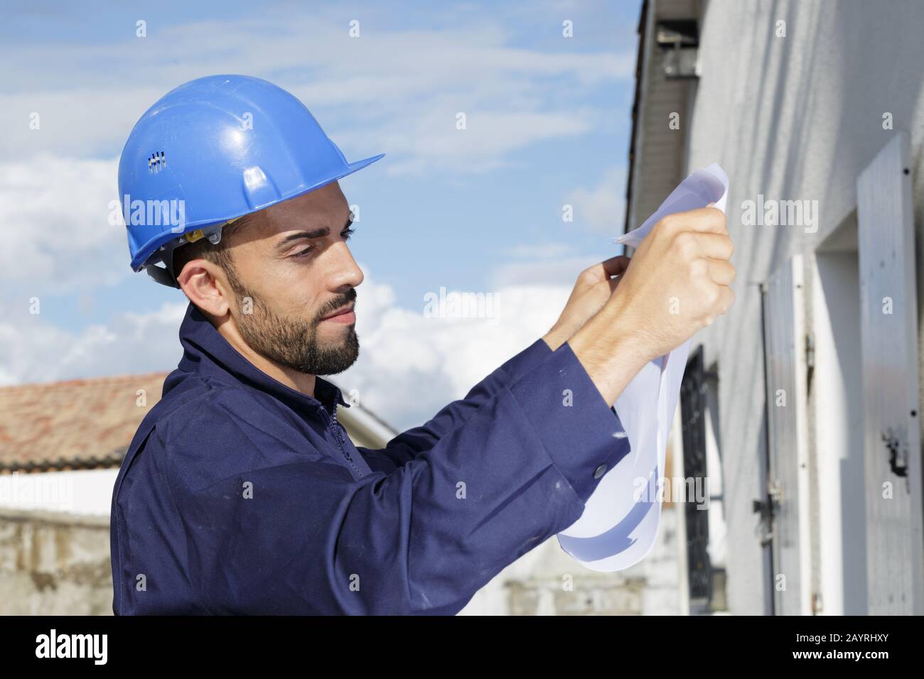 builder with construction plan outdoors Stock Photo - Alamy