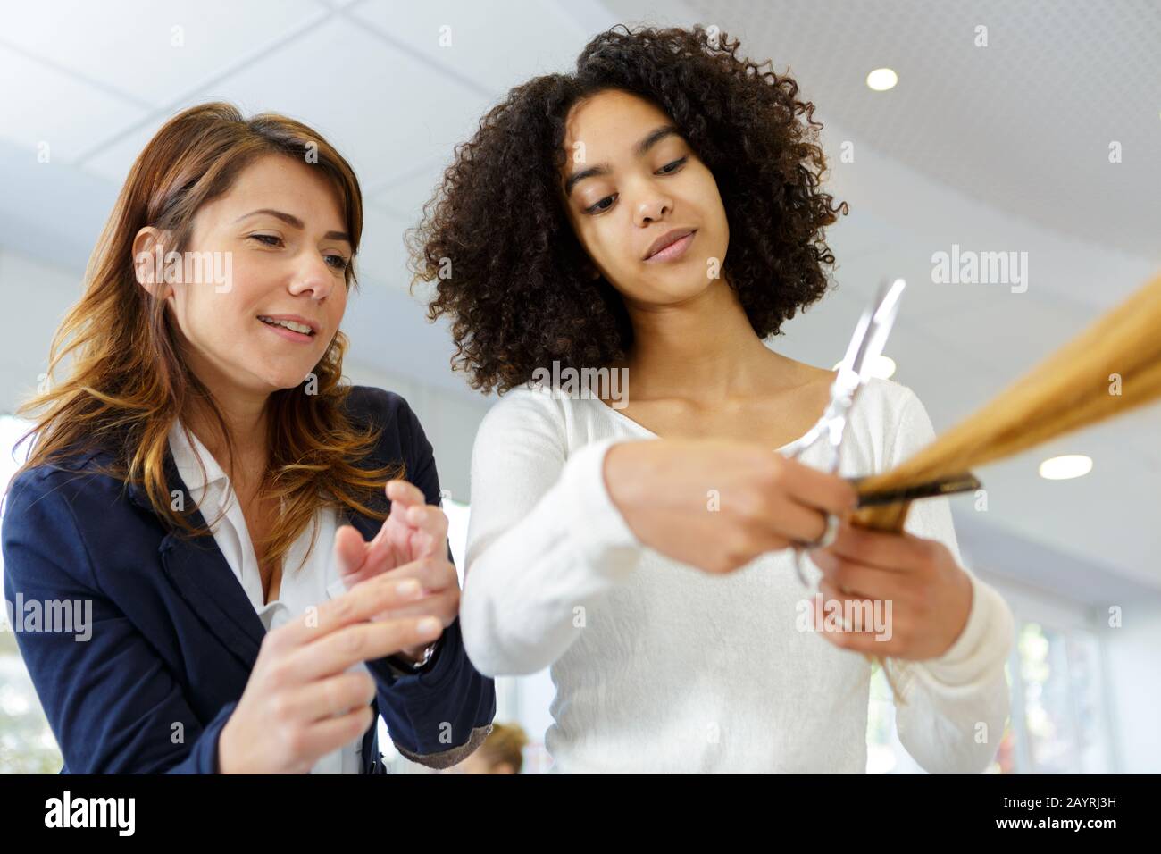salon trainer supervising apprentice on hair cutting Stock Photo - Alamy