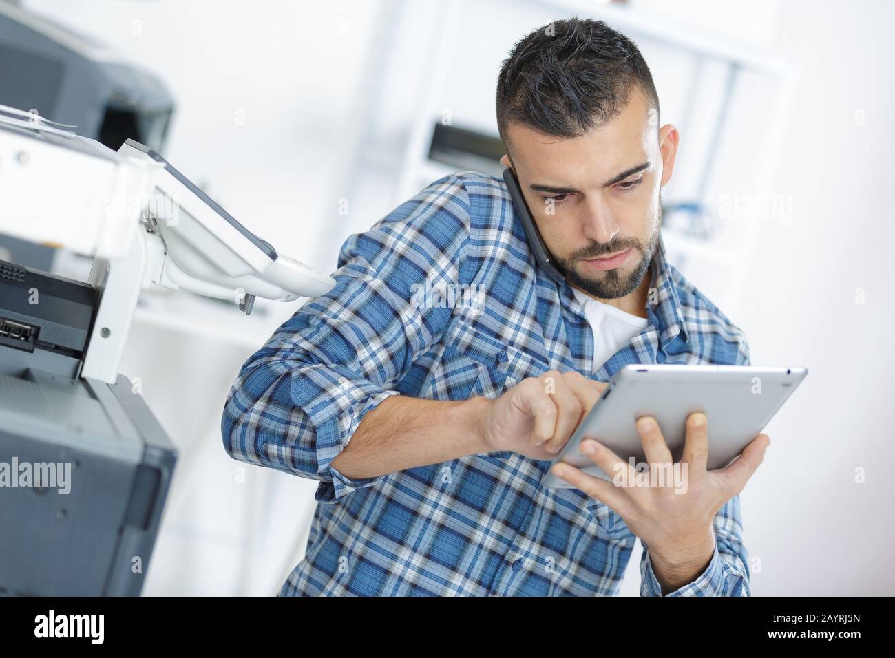 man on repair and maintenance office printer Stock Photo - Alamy