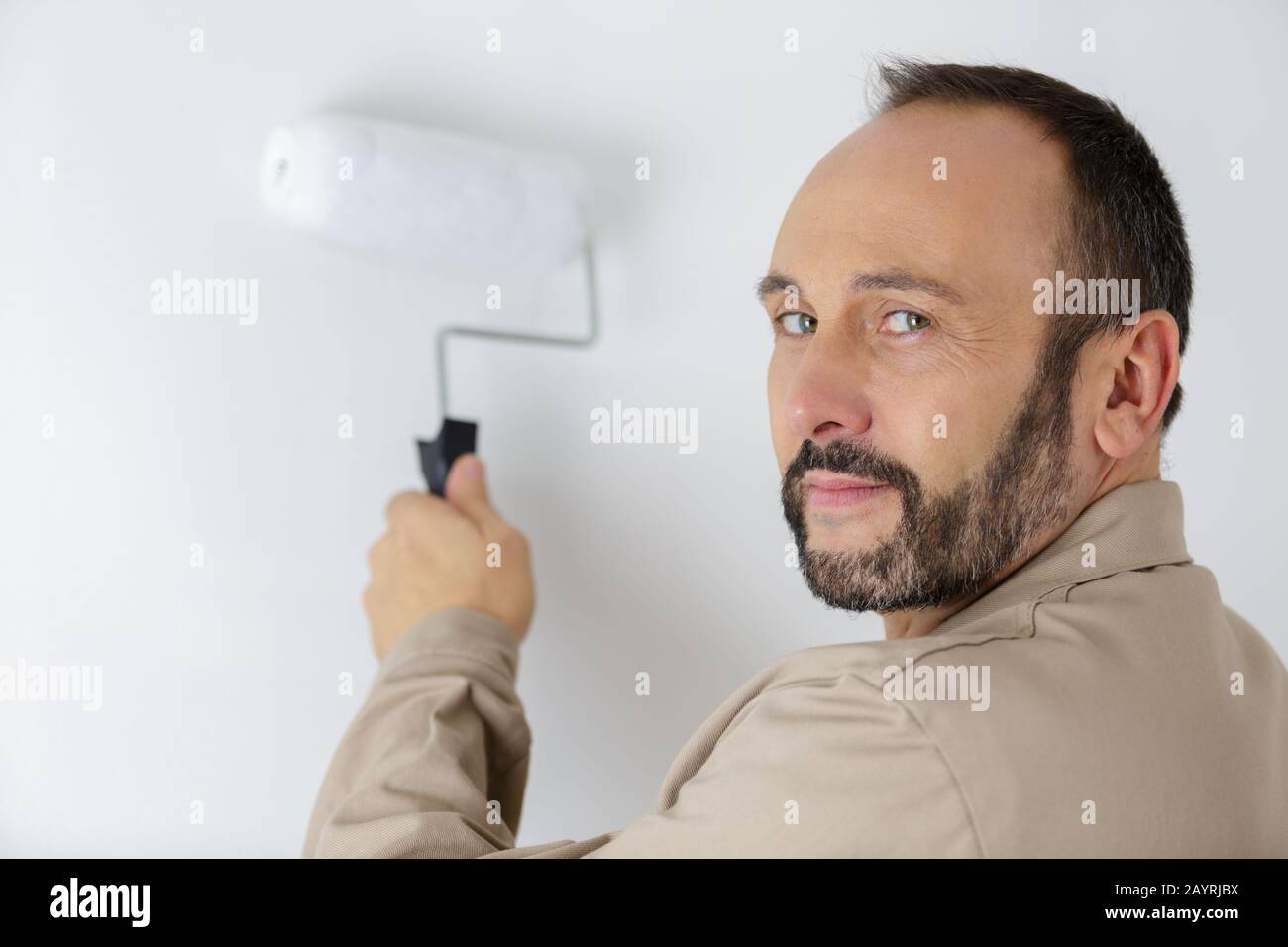 worker painting wall in room Stock Photo - Alamy