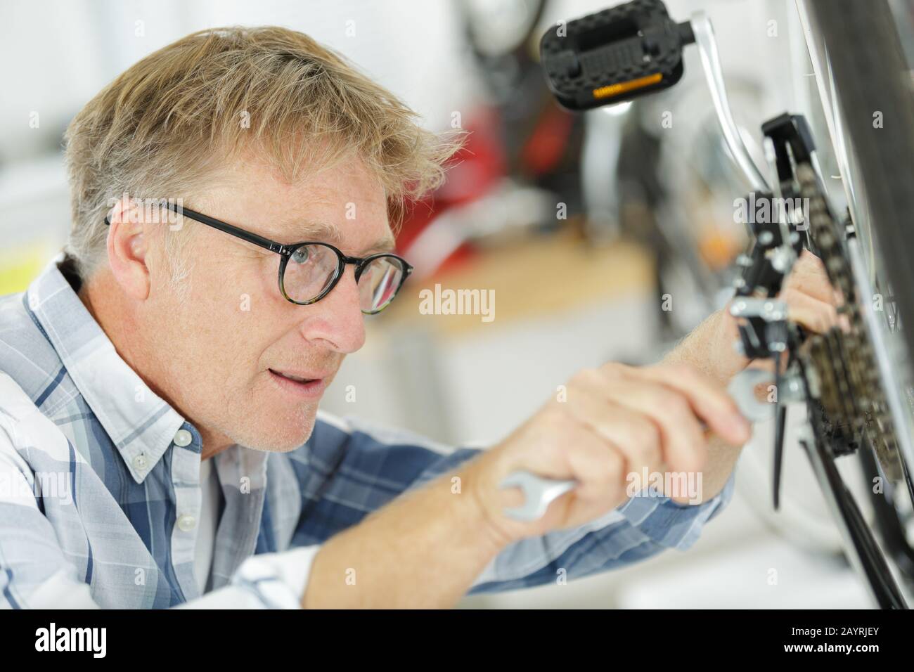 a senior man fixes his granddaughters bikes brakes Stock Photo - Alamy