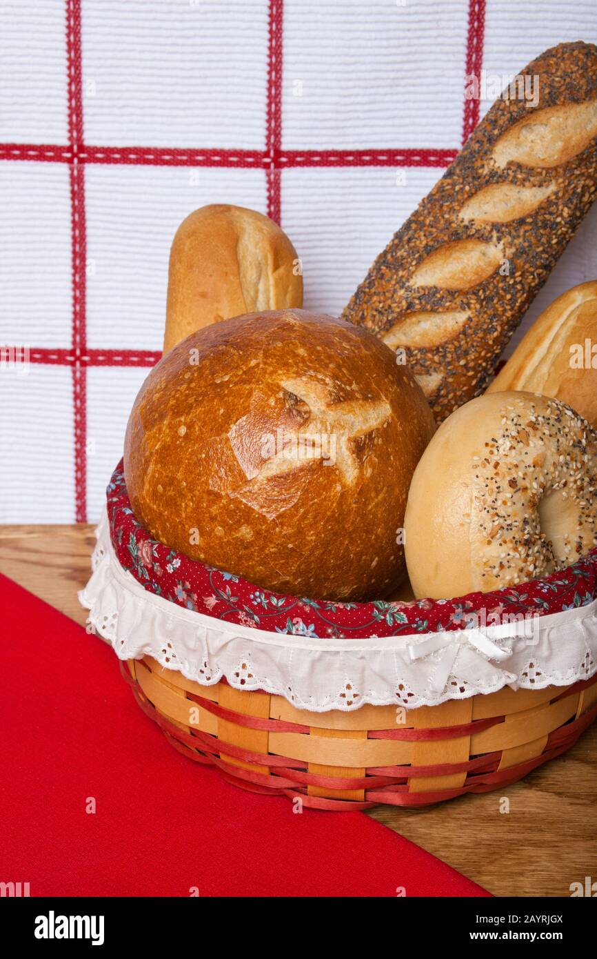Variety of home made breads in a cloth-lined wicker basket, including ...