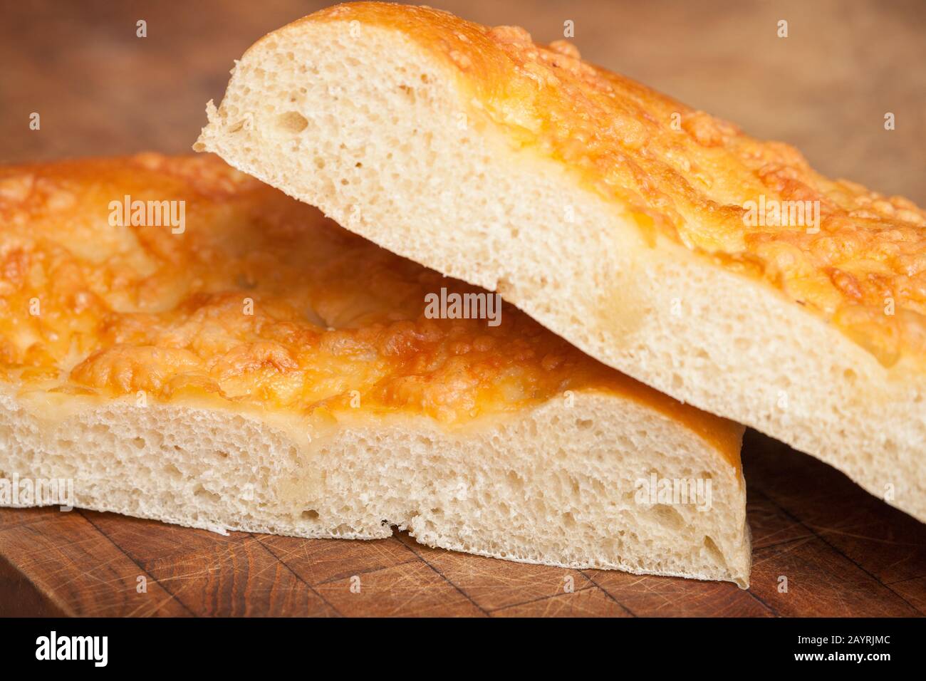 Loaf of focaccia cut in half, showing the interior, on a rustic wood ...