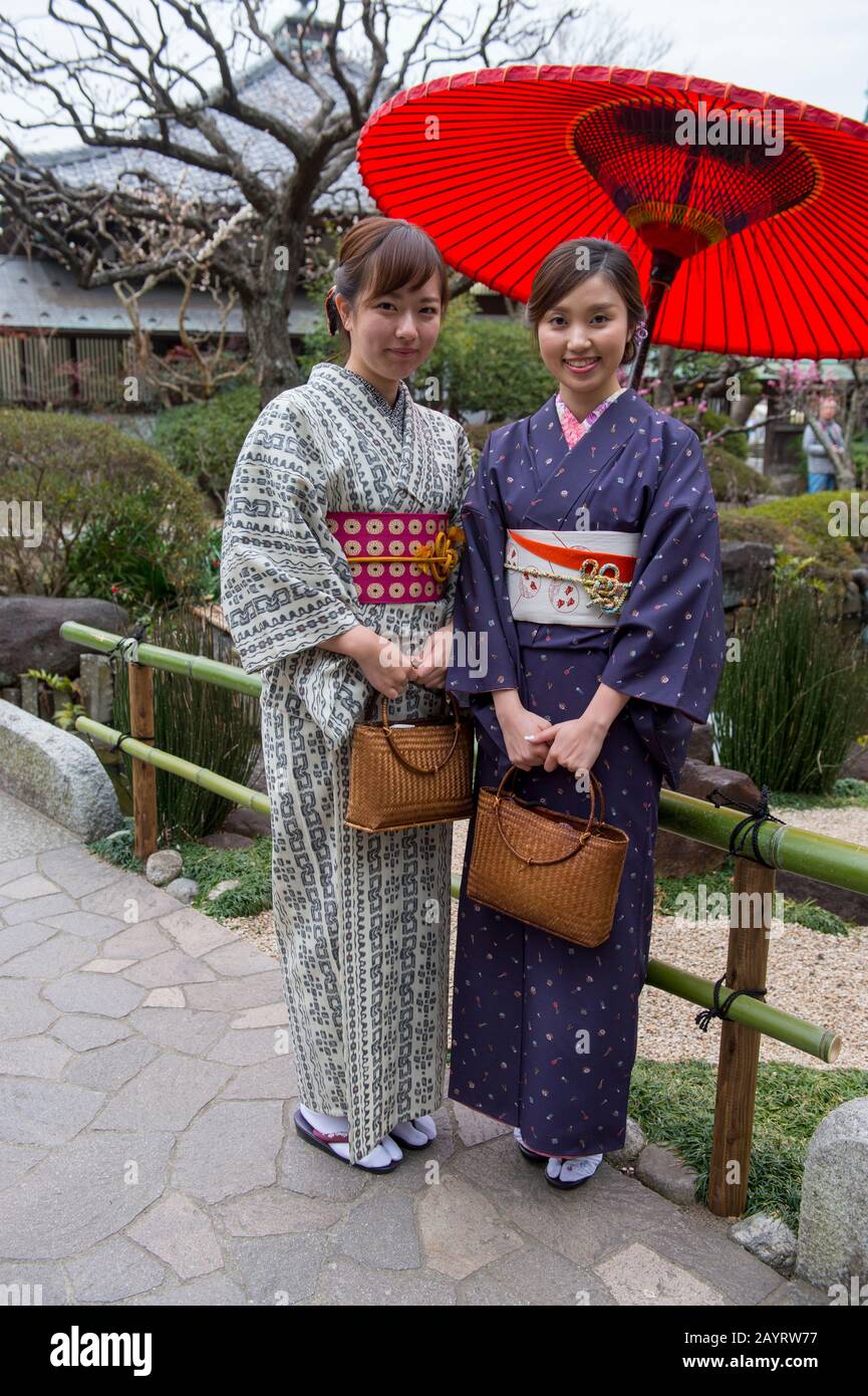 Two Japanese young women wearing traditional kimonos posing in front of ...