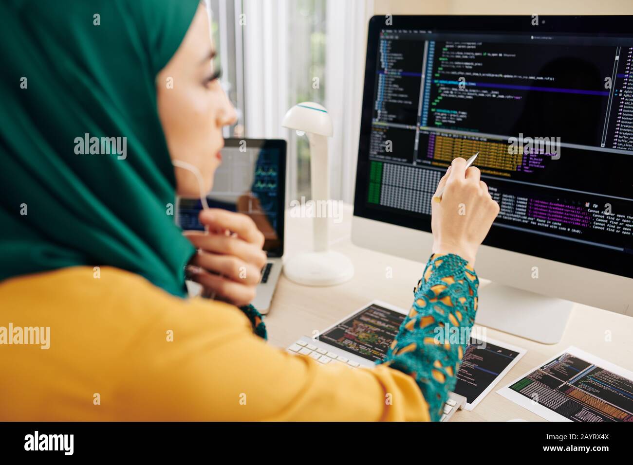 Young Muslim Software Developer Checking Strings In Programming Code On Computer Screen Stock