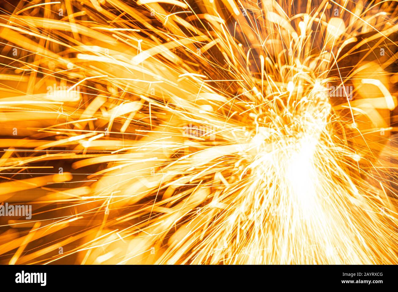 Bright orange and yellow sparks on a black background. A stream of ...