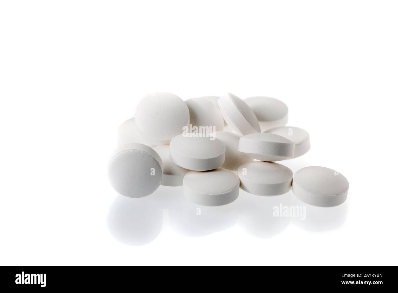 Close-up of piled round tablets on white background in sidelight with ...