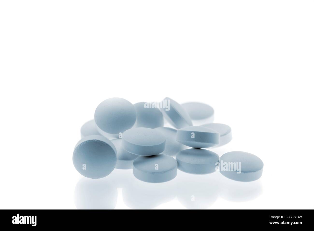 Closeup of piled round tablets isolated on white background in ...