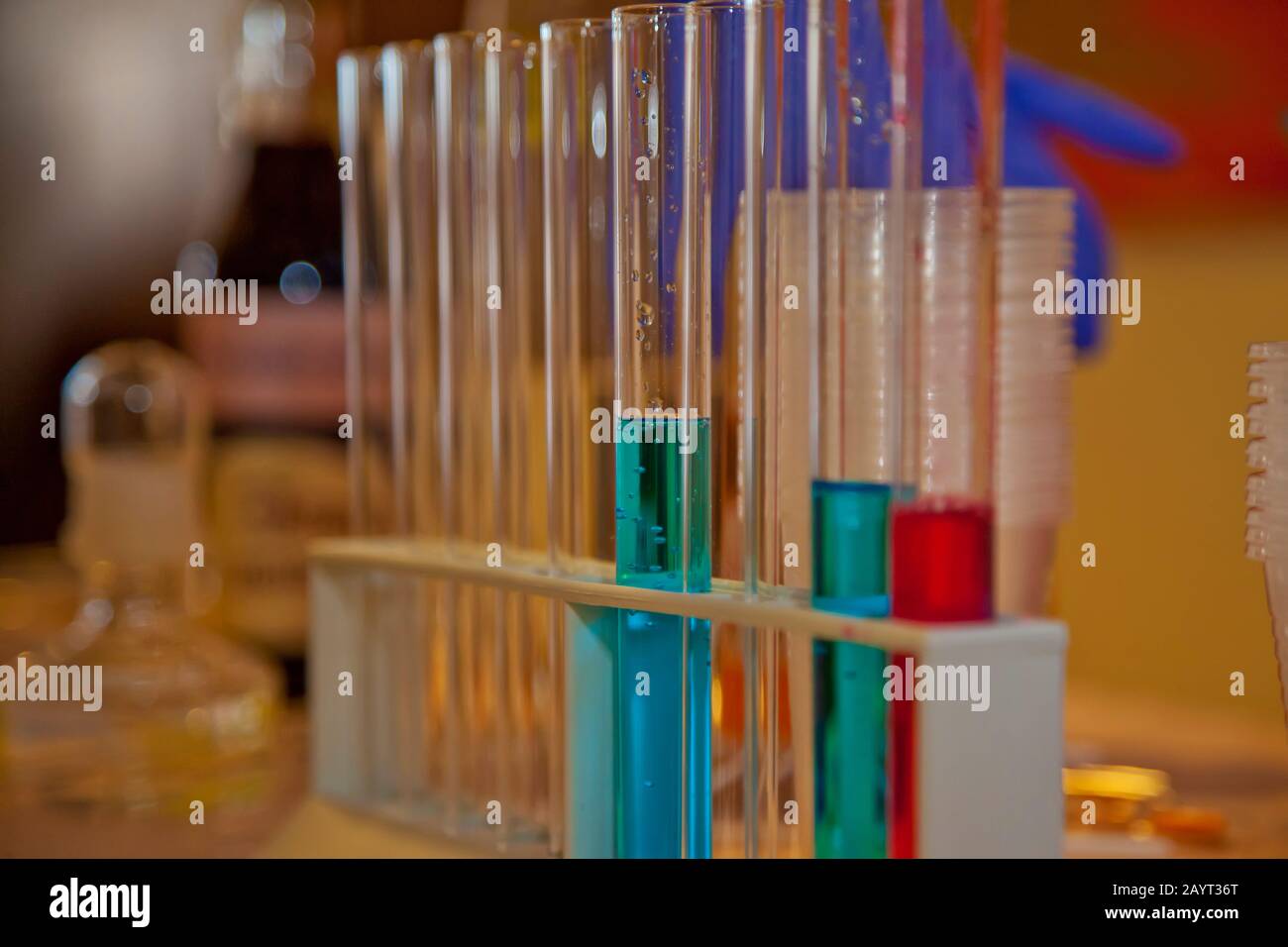 numerous multi-colored test tubes with different chemicals are placed ...