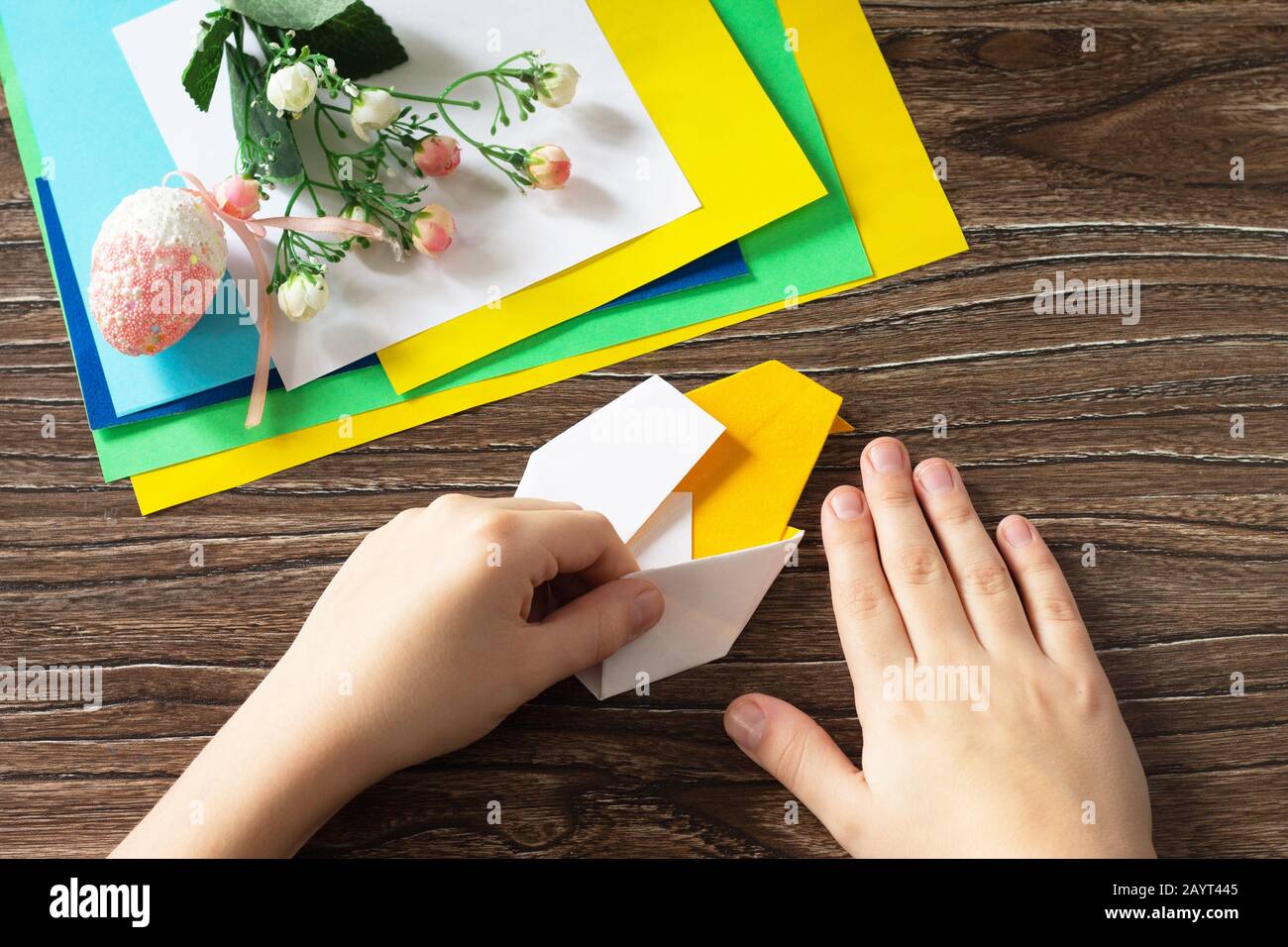 Origami instruction, step 13. The child fold the origami Easter chick ...