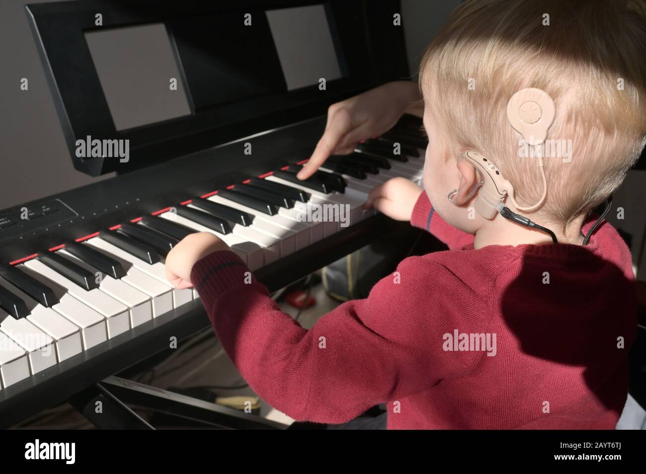 A Boy With A Hearing Aids And Cochlear Implants Playing Piano Stock ...