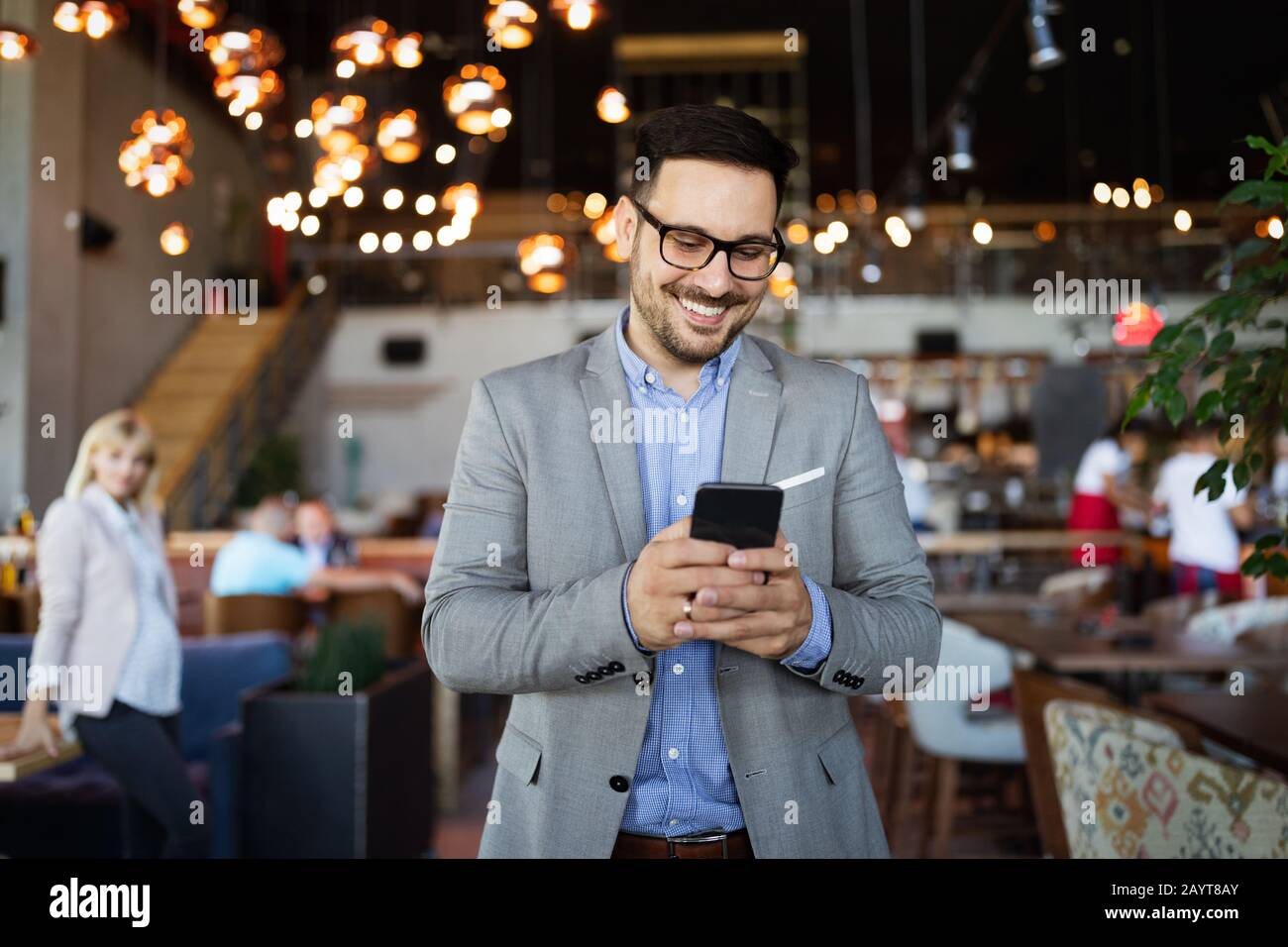 Handsome business man receiving a happy message on his cell phone Stock ...