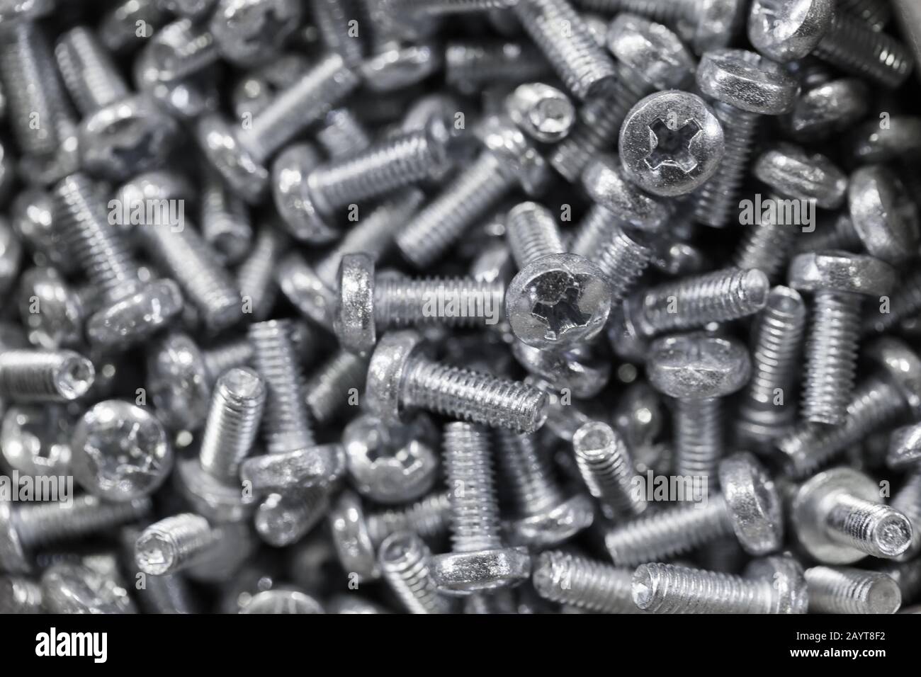 Pile of shiny new bolts, close-up background photo with selective soft ...