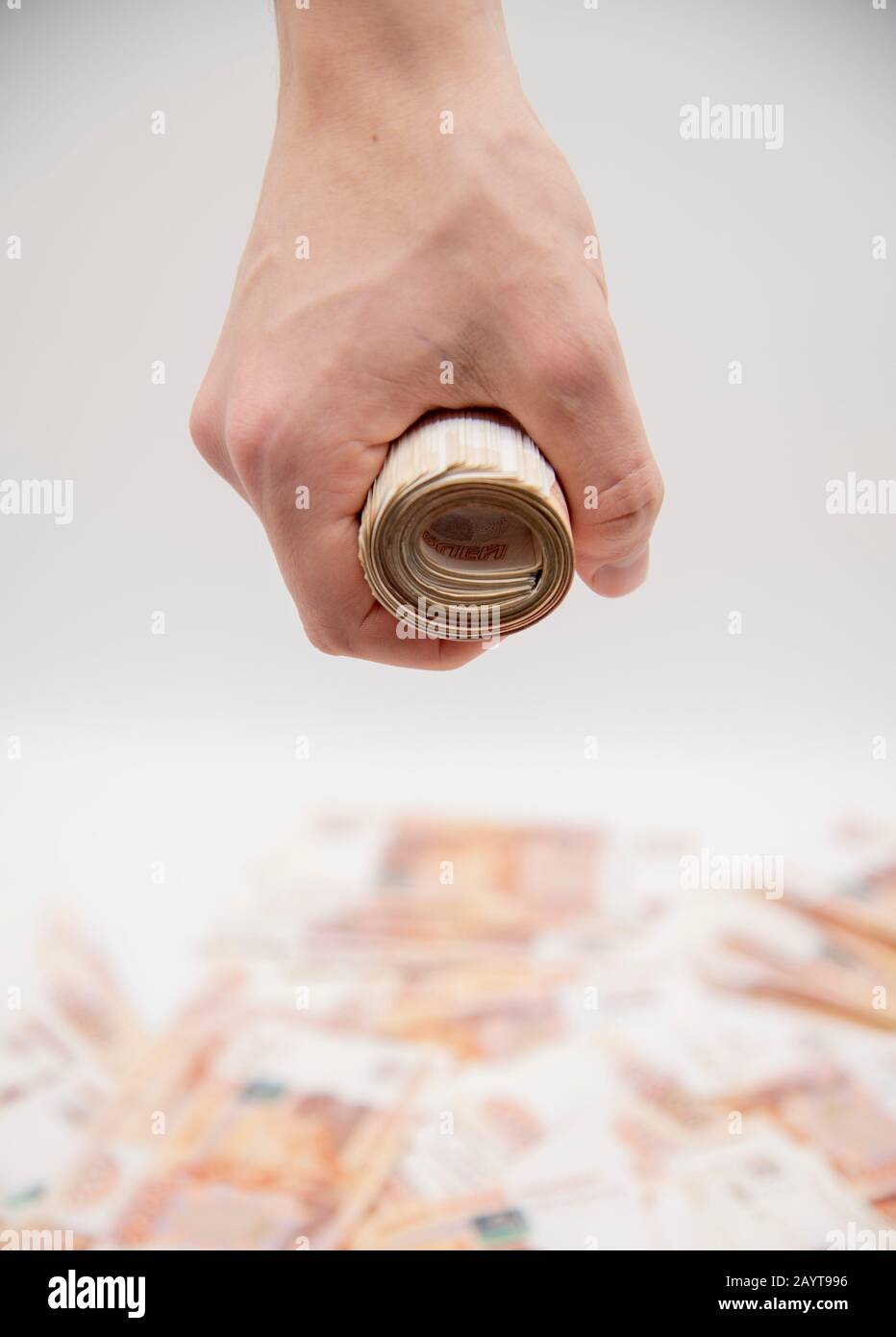 A man's hand is clenched into a fist holding twisted five-thousand ...