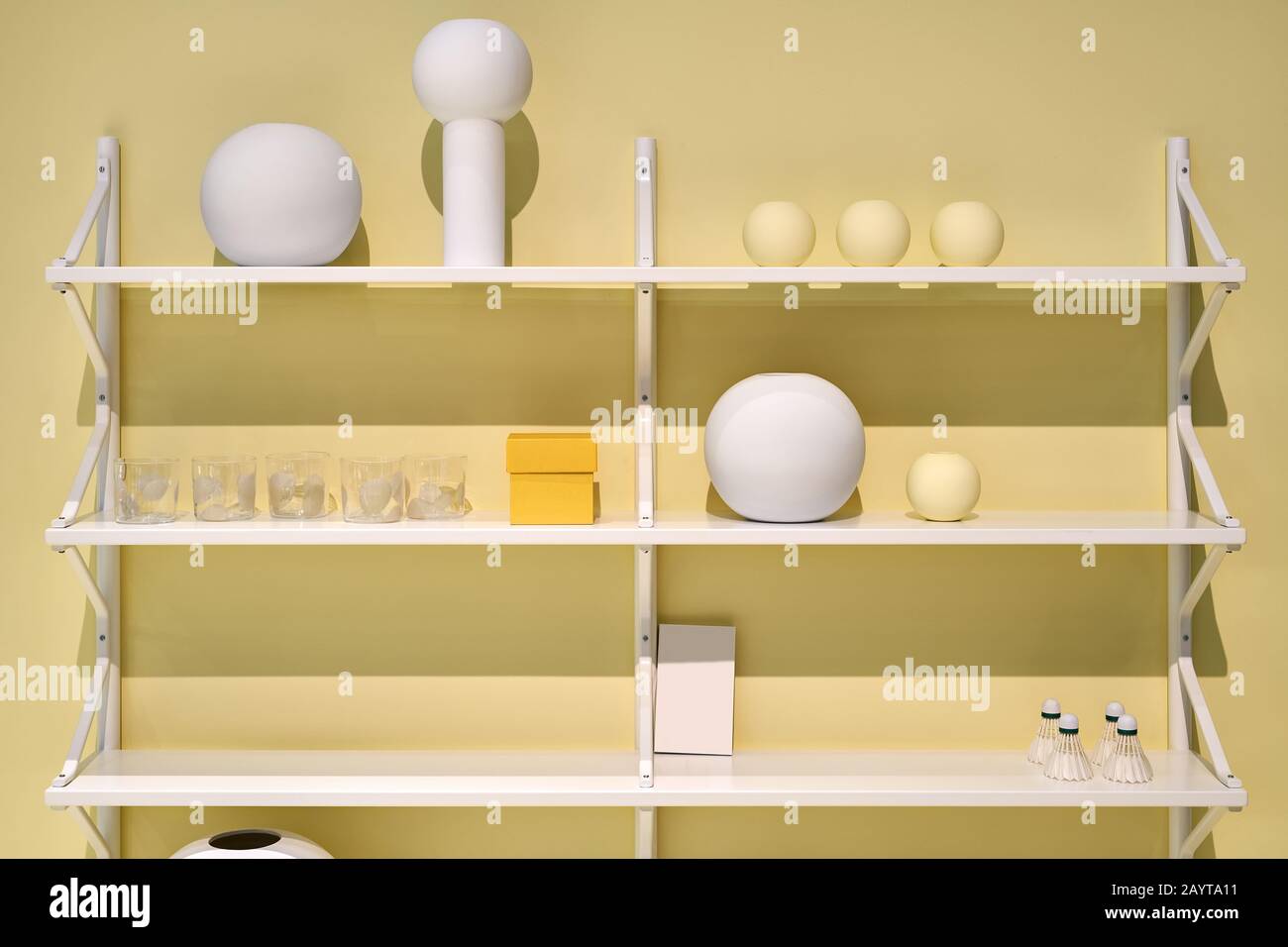 Interior with yellow walls and shelves with decor Stock Photo - Alamy