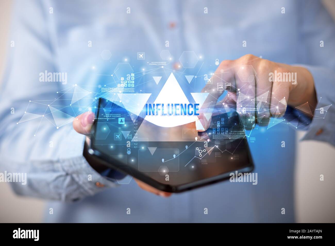 Businessman holding a foldable smartphone with INFLUENCE inscription ...