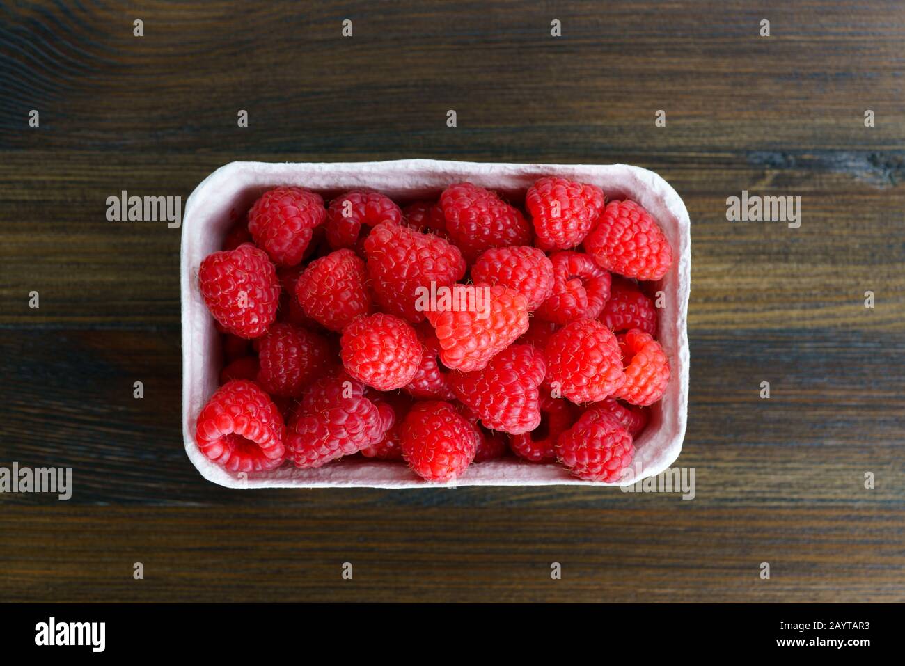 Freshly picked organic raspberries in recycled paper cup. High ...