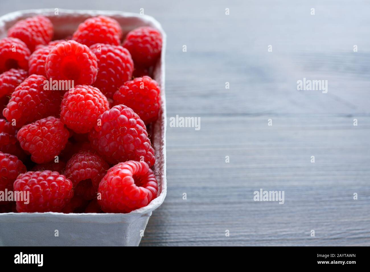 Freshly picked organic raspberries in recycled paper cup. High ...