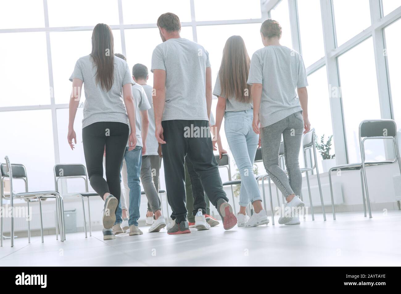 rear view. a group of young people walking into the conference room ...