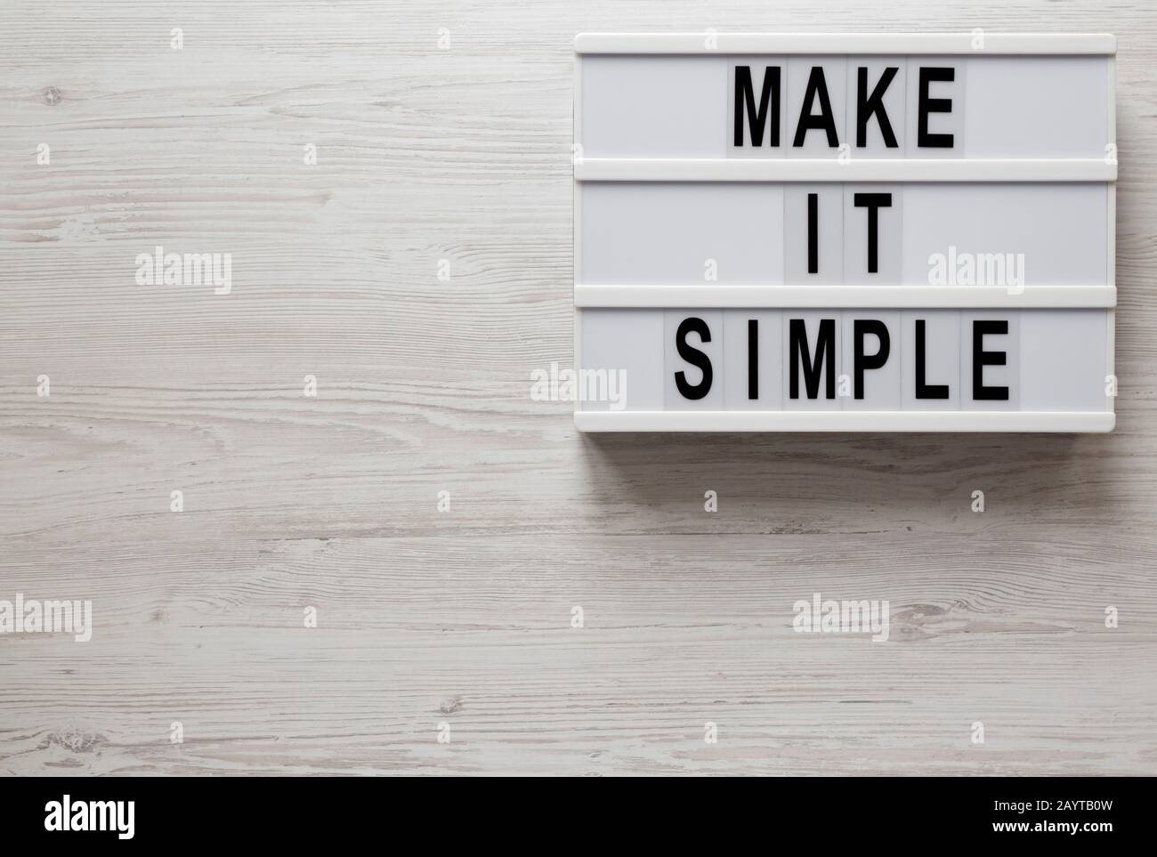 'Make it simple' words on a lightbox on a white wooden background ...