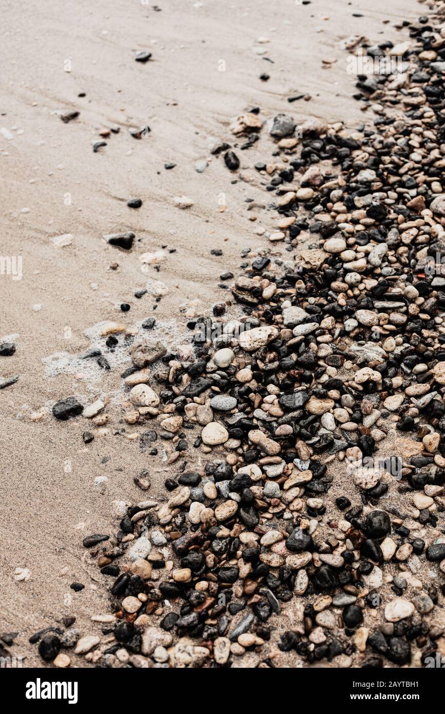 Different texture on the beach - water and sand, stones and pebbles ...