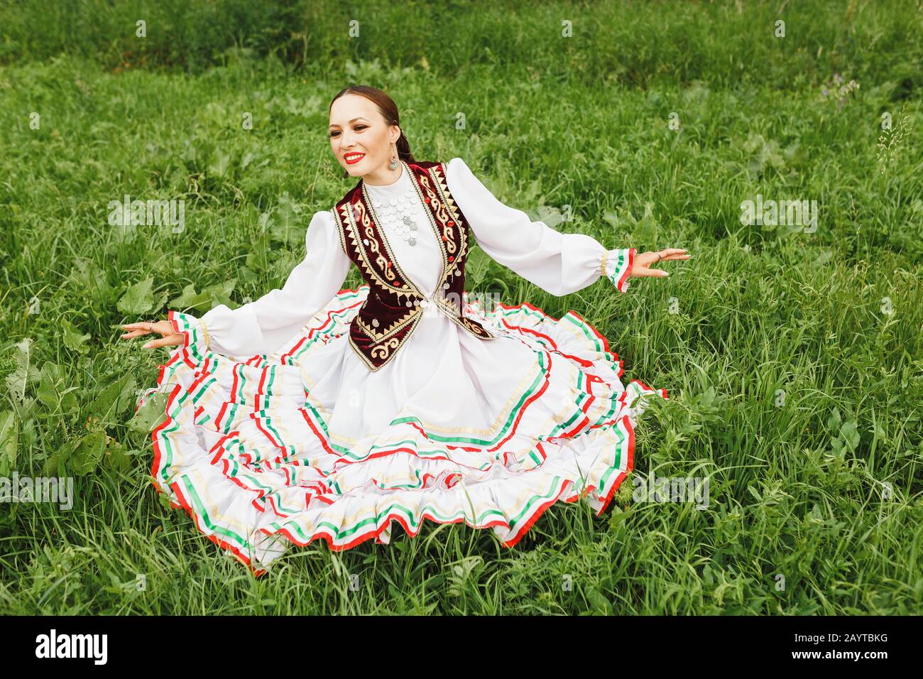 A woman in traditional embroidered Turkic Eastern clothes performs a ...