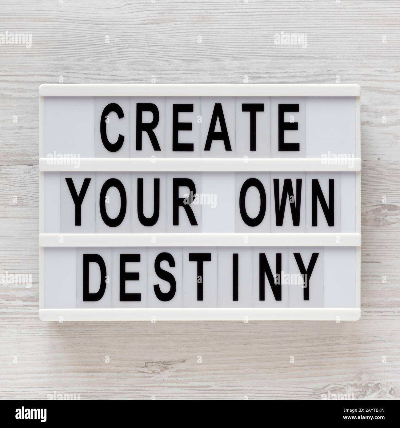 'Create your own destiny' words on a modern board on a white wooden ...