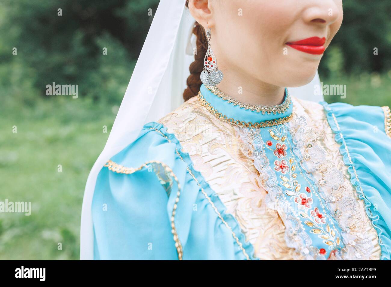 A woman in traditional embroidered Turkic Eastern clothes performs a ...