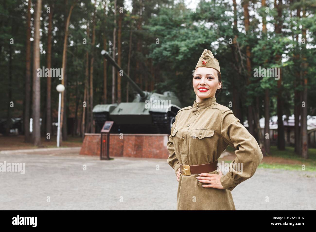 A girl in an old Soviet military uniform salute in park memorial with ...