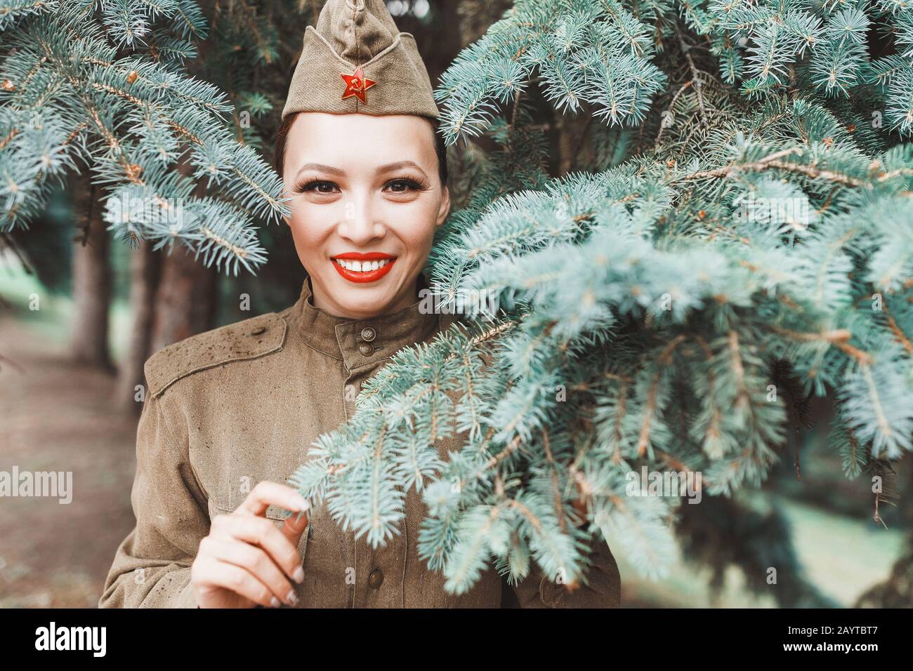 A girl in an old Soviet military uniform salute in park memorial. World ...