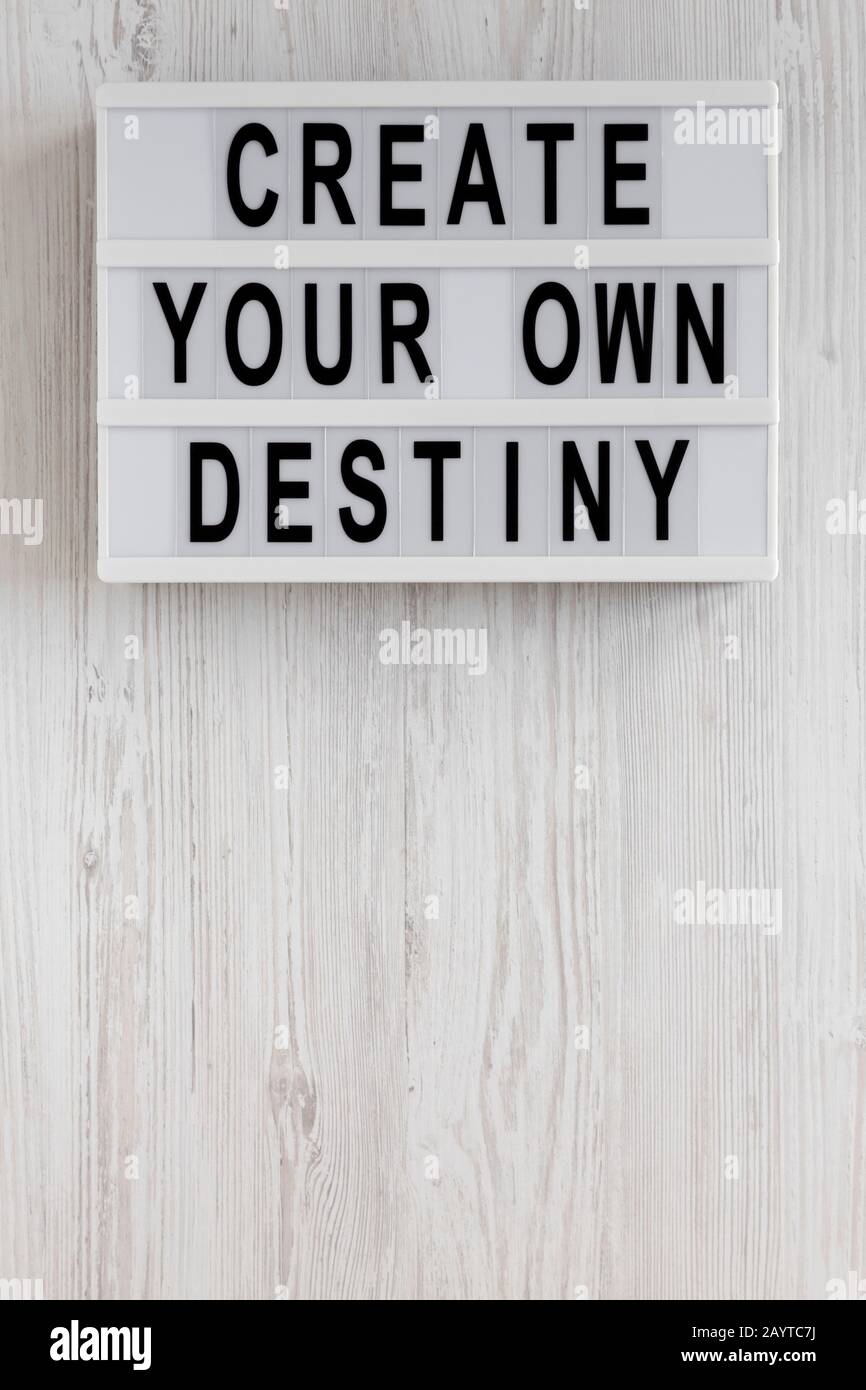 'Create your own destiny' words on a modern board on a white wooden ...
