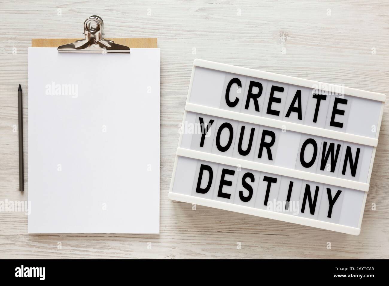 'Create your own destiny' words on a lightbox, clipboard with blank ...