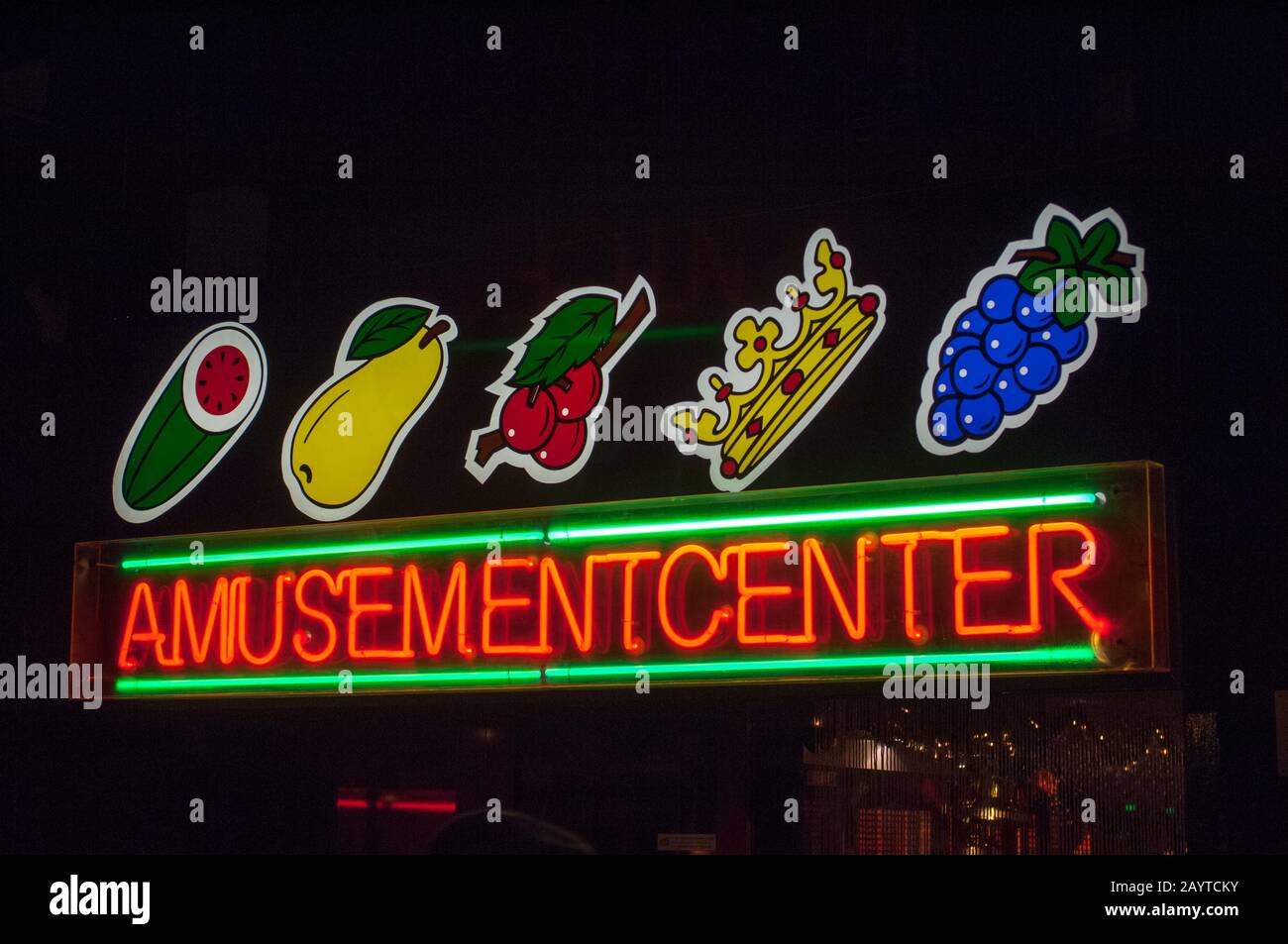 A street scene at night with colorful neon signs of amusement center in ...