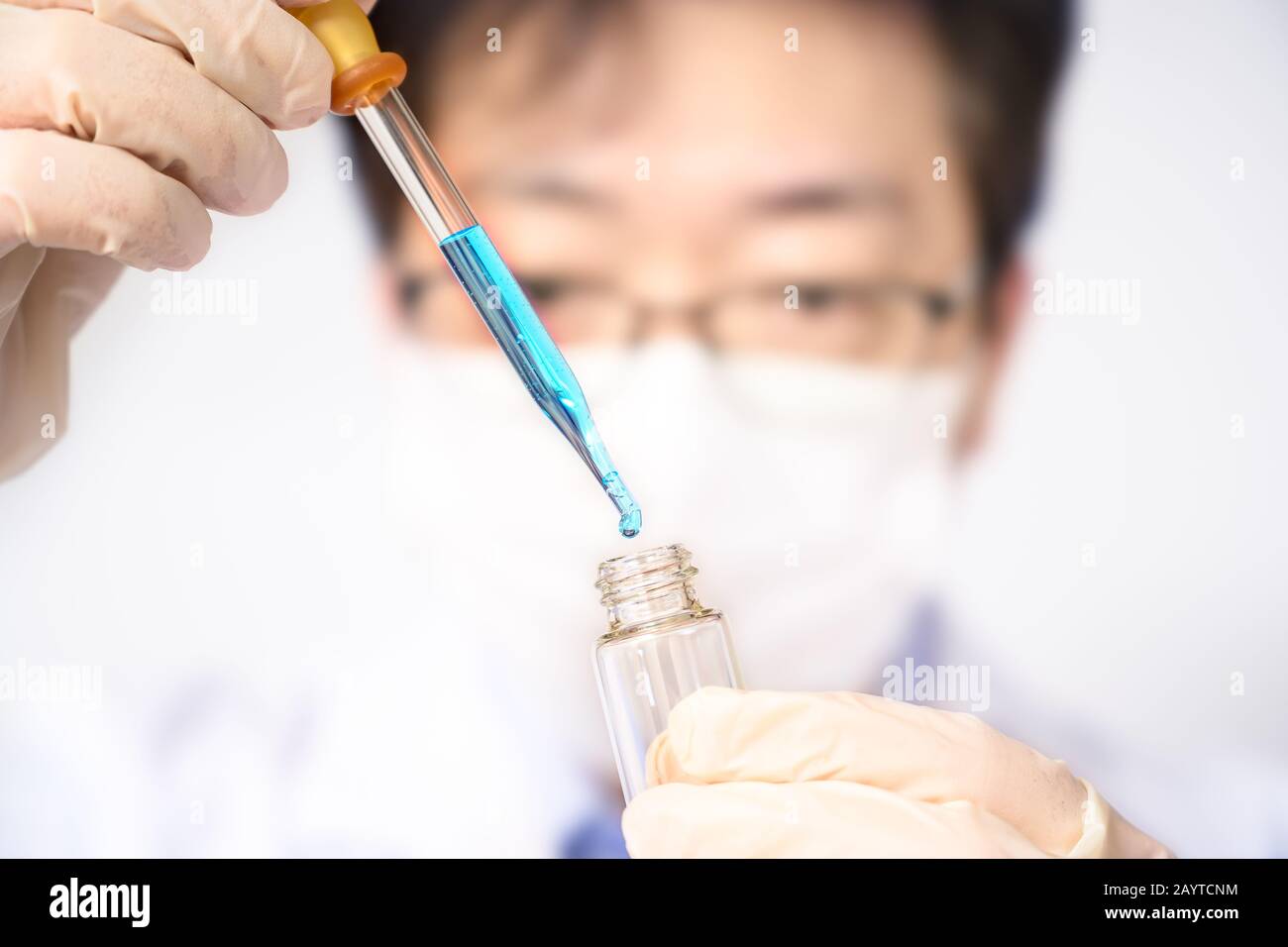 Scientist hands with dropper or pipette, examining samples and liquid ...