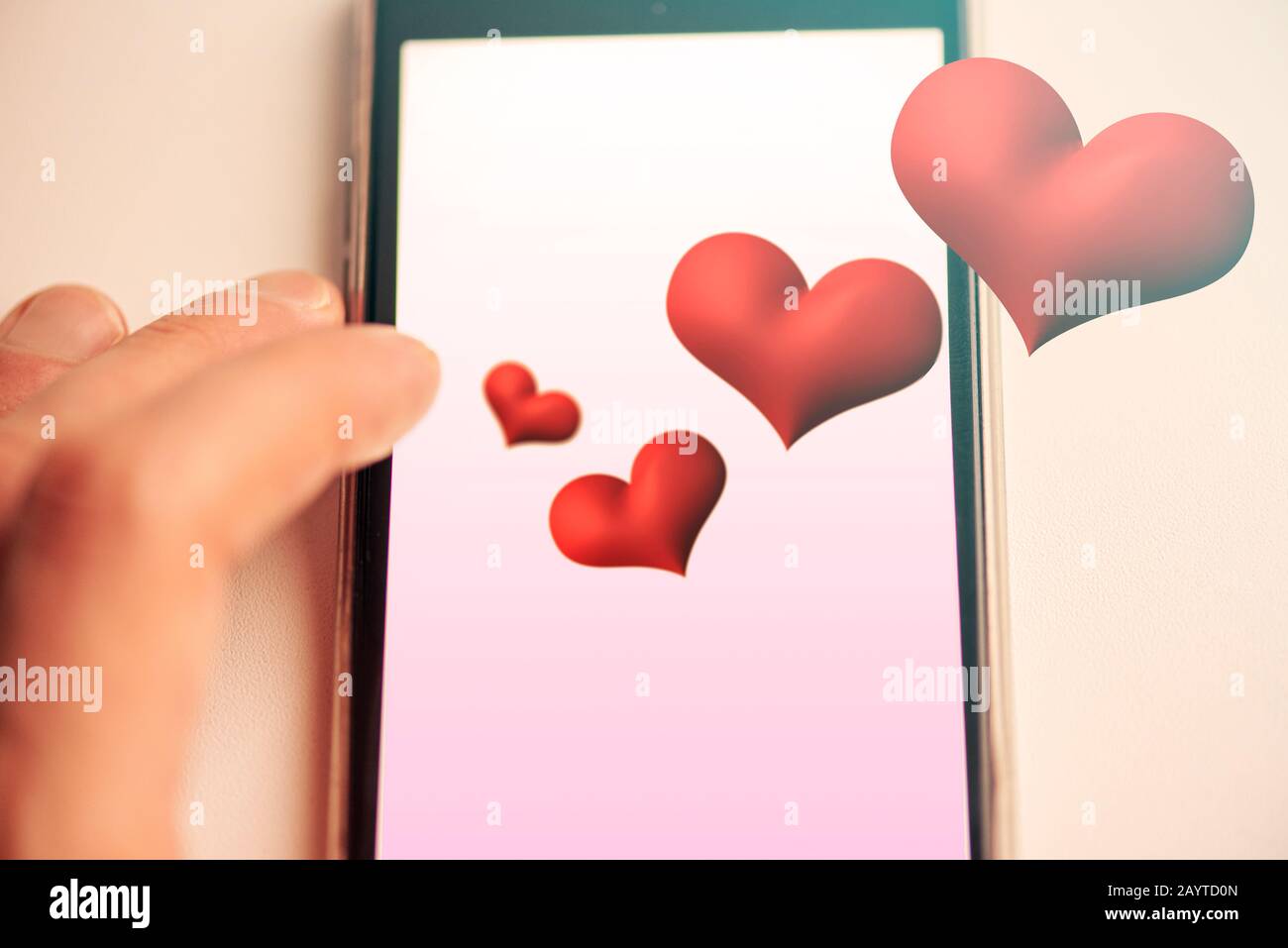 Man touching Blank pink Screen of Mobile Phone with Flying red Heart ...