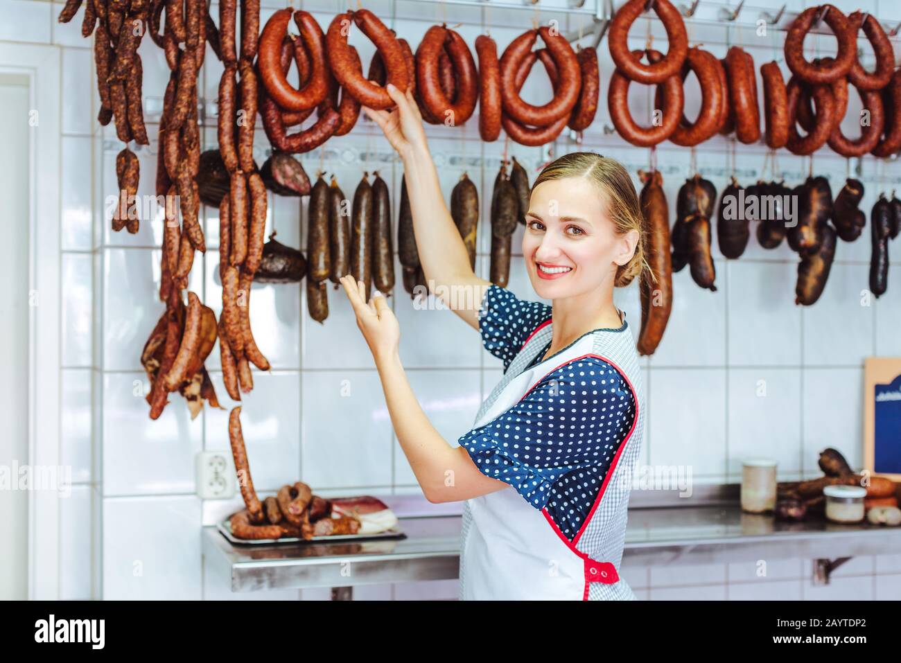 Woman actively recommending sausages in her butchery Stock Photo - Alamy