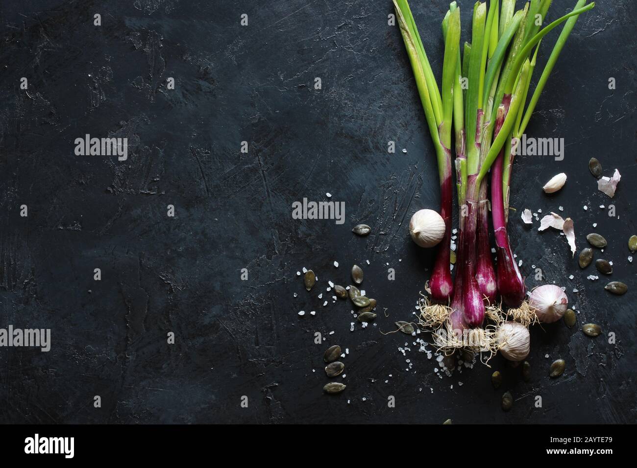purple spring onions on dark table background Stock Photo - Alamy