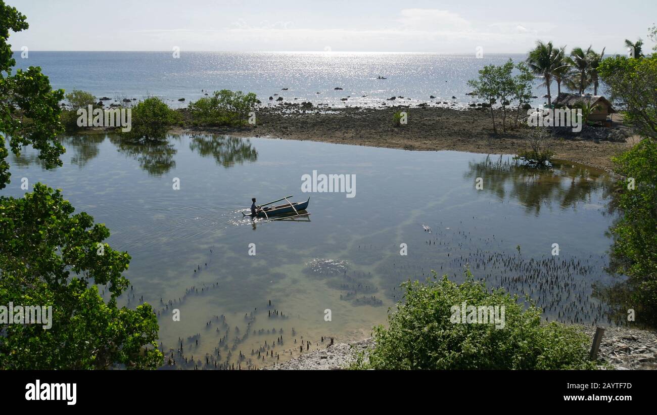 Small water inlet from seawater with a silhouette of a boat and a boy ...