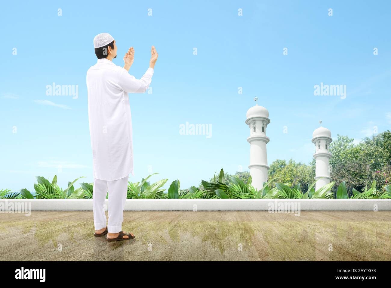 Asian Muslim man standing while raised hands and praying on the mosque ...