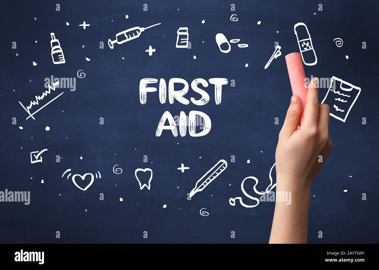 Hand drawing FIRST AID inscription with white chalk on blackboard ...