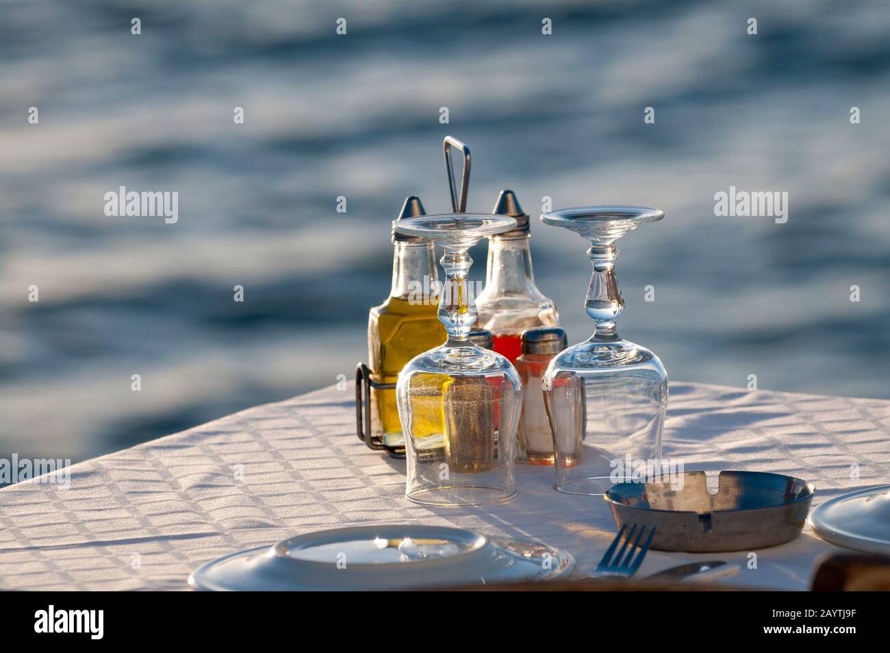 Mediterranean seaside table set with olive oil and vinegar waiting for ...