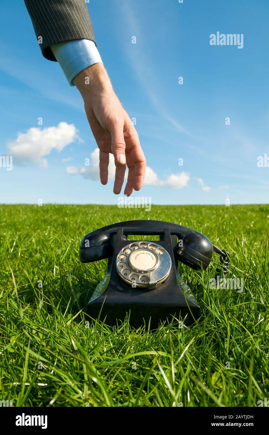 Hand of unrecognizable businessman reaching for the receiver of an old ...