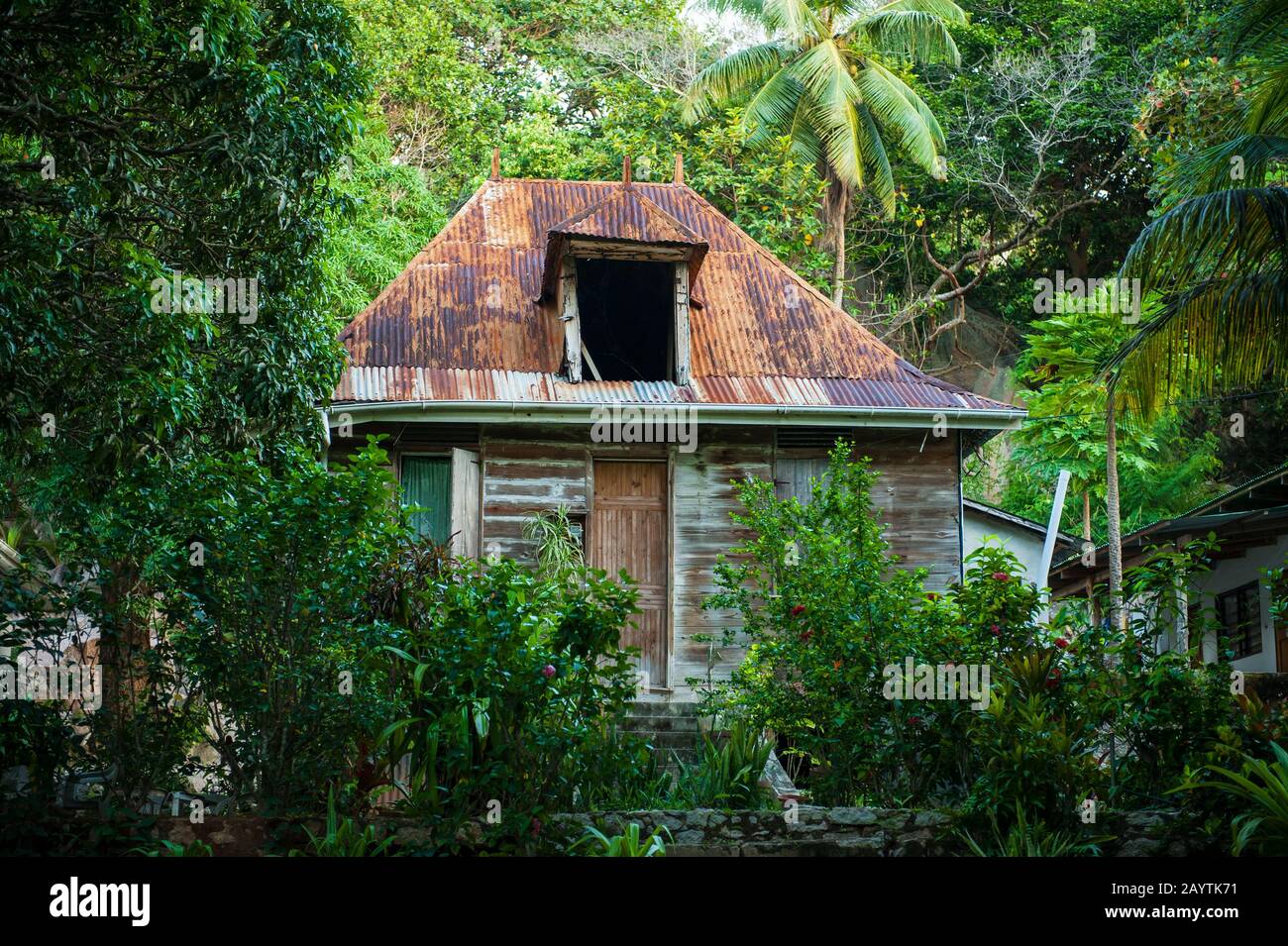 Weathered wooden shack with rusted roof set into a tropical island ...