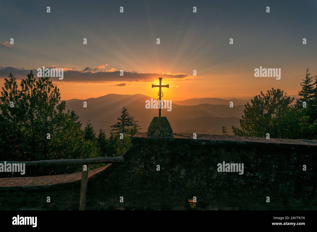 Epic landscape with mountains at sunset and catholic cross with sun ...