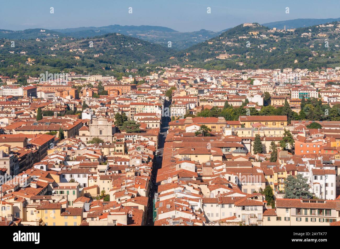 Aerial of Florence cityscape with red-tiled rooftops and mountains in ...